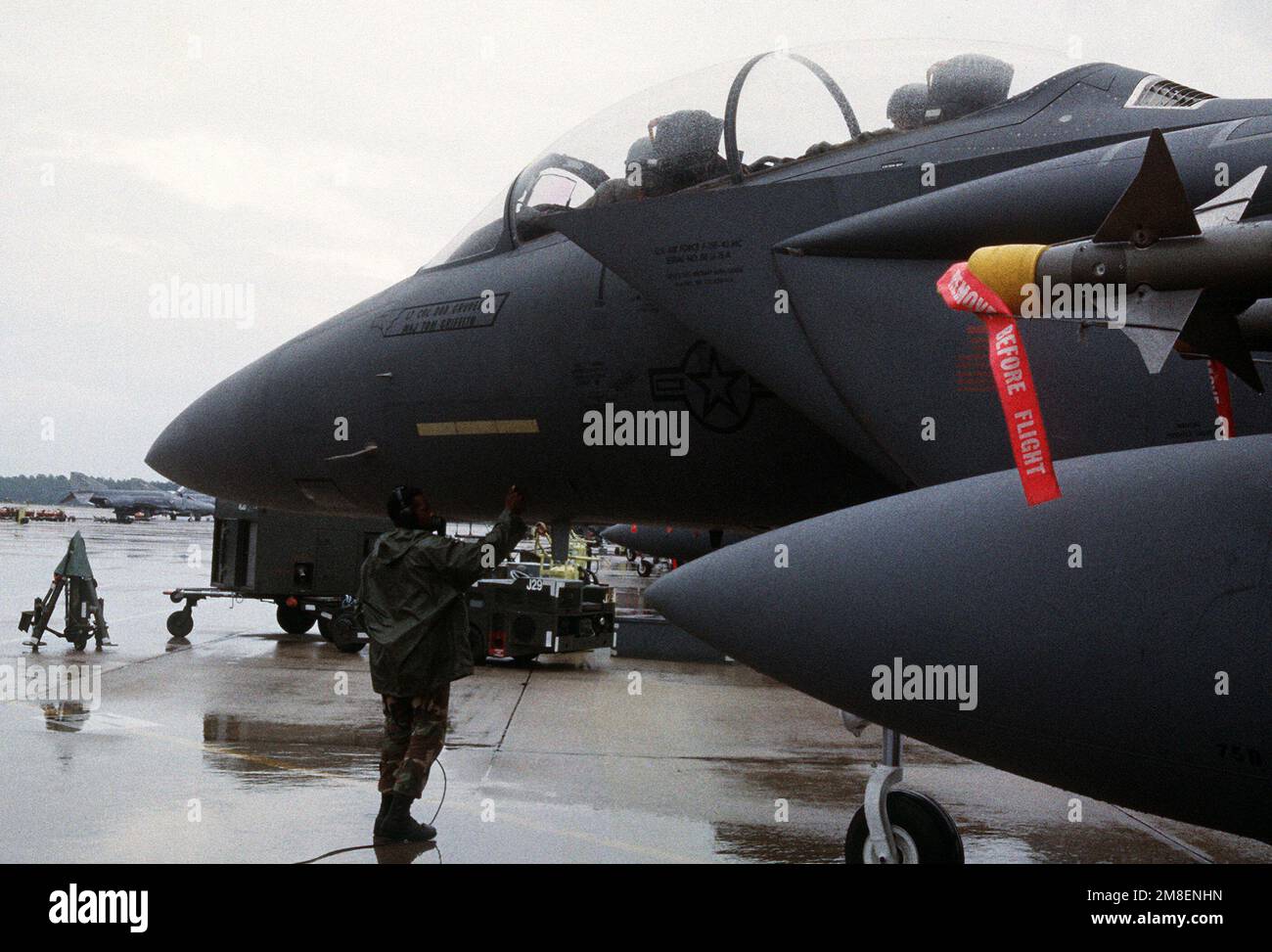 A ground crew member performs a preflight check on an F-15E Eagle ...