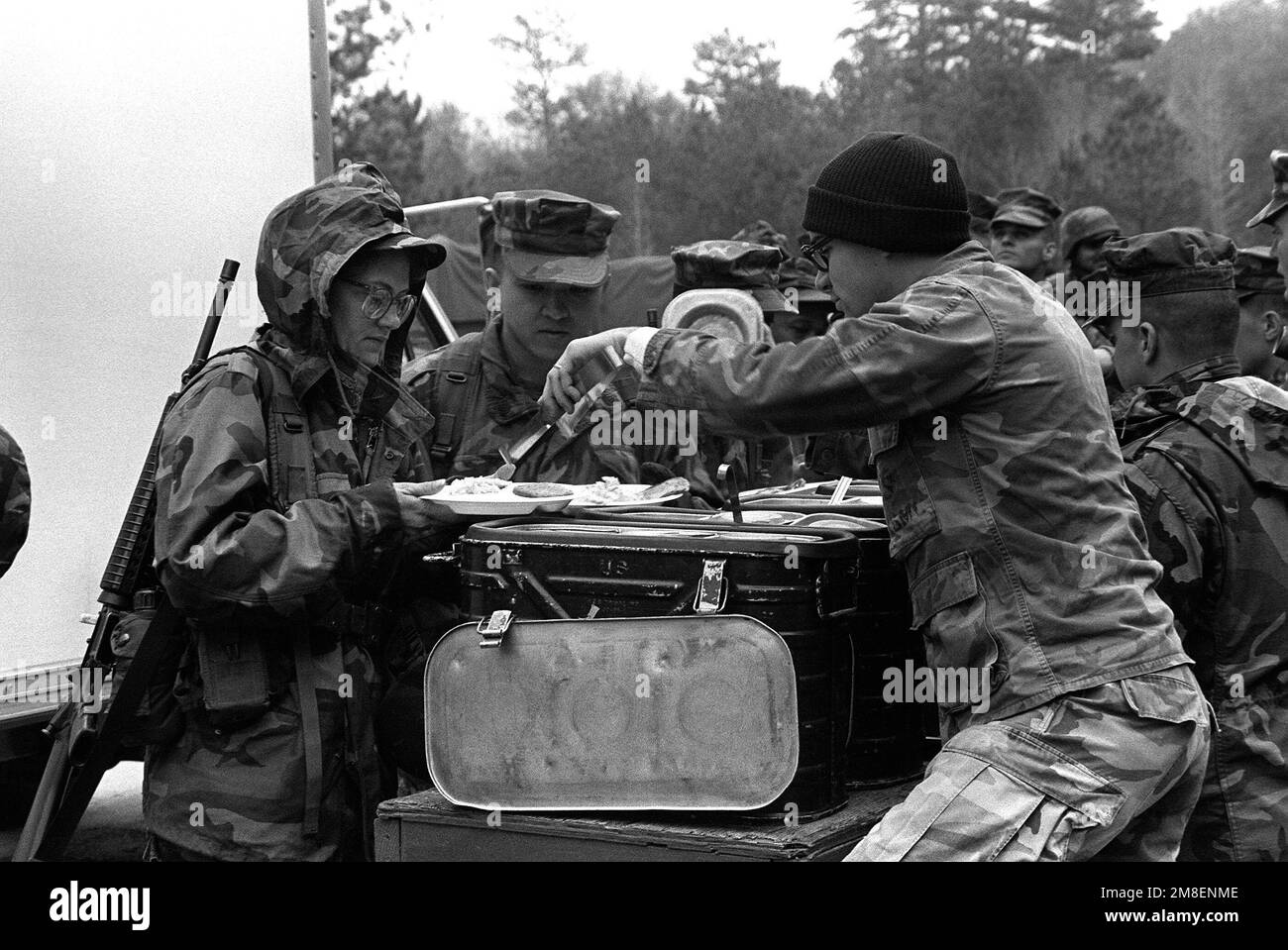 CPL B. Keller serves SSGT A. J. Hillman a hot meal as SSGT N. Chotikul ...