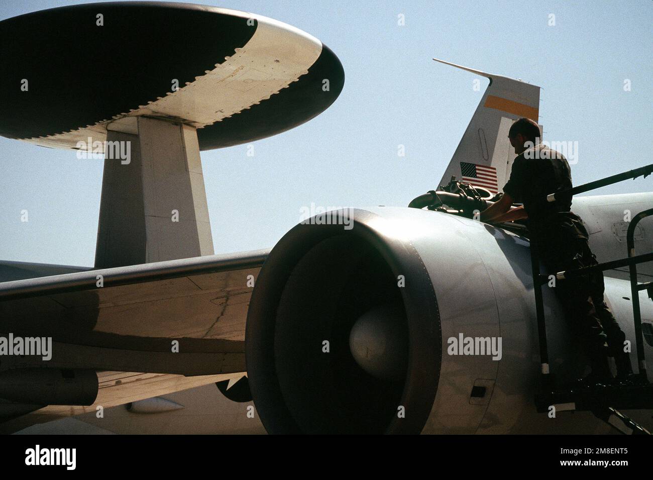 A ground crew works on an engine of an E-3A Sentry Airborne Warning and ...