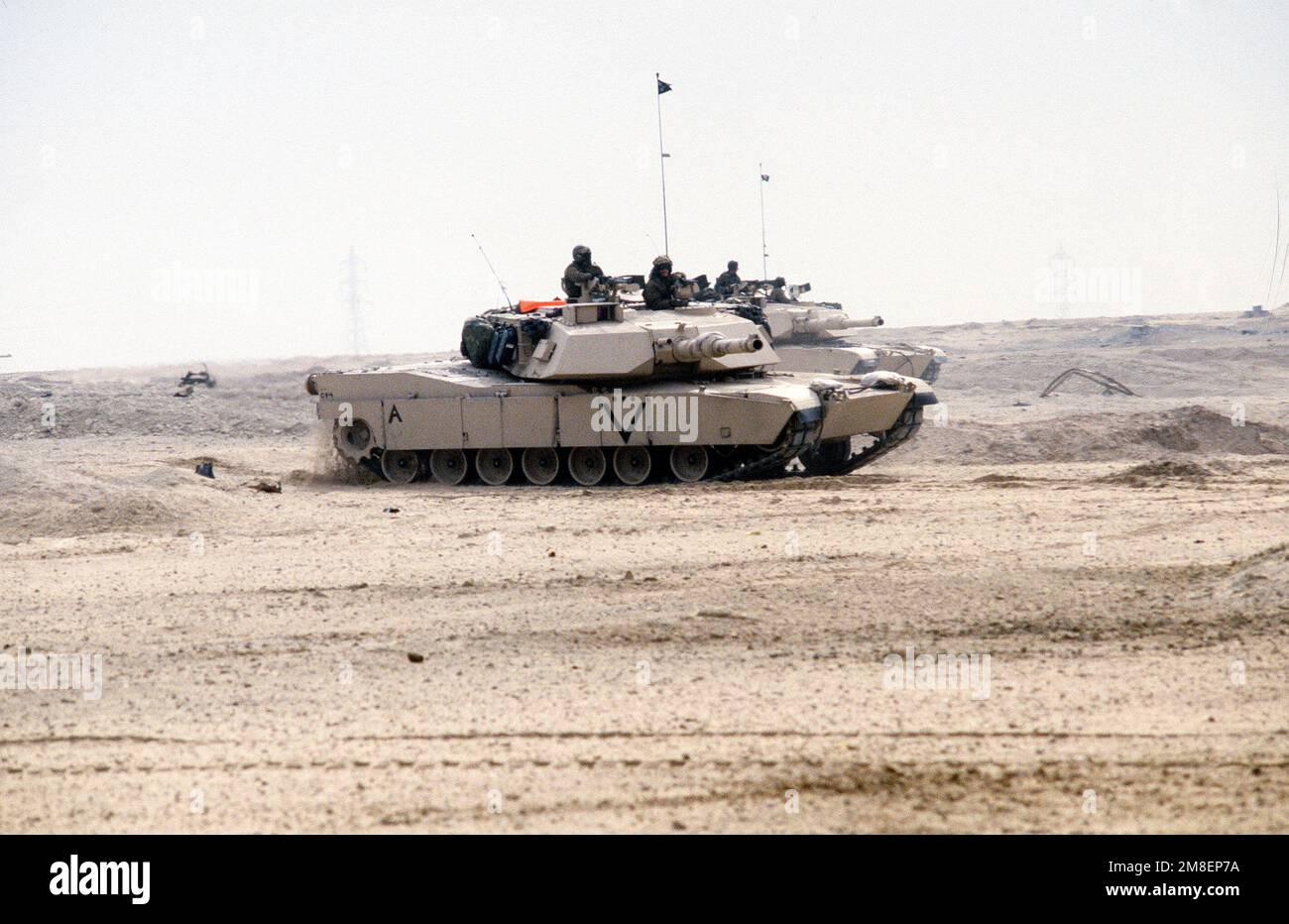 Two Marine Corps M-1A1 Abrams main battle tanks move across the desert ...