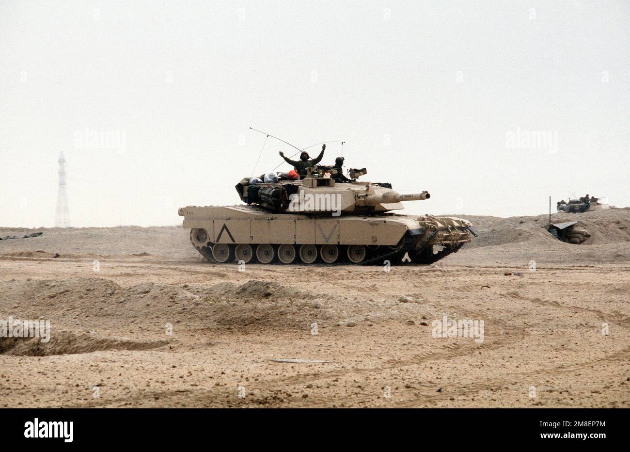A Marine waves from the commander's hatch of an M-1A1 Abrams main ...