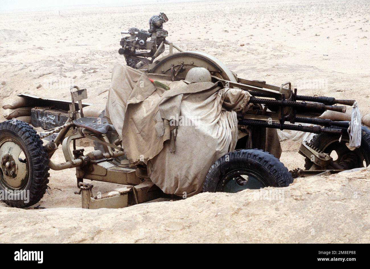 An abandoned Iraqi ZPU-4 anti-aircraft machine gun lies in the desert ...