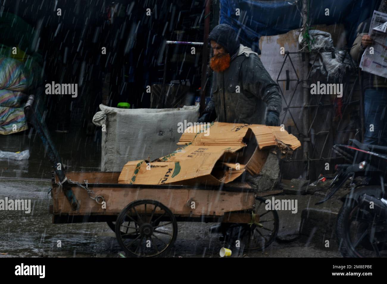 Kashmir, India. 13th Jan, 2023. An old man cover his cart as it is is Snows heavy in Srinagar ...