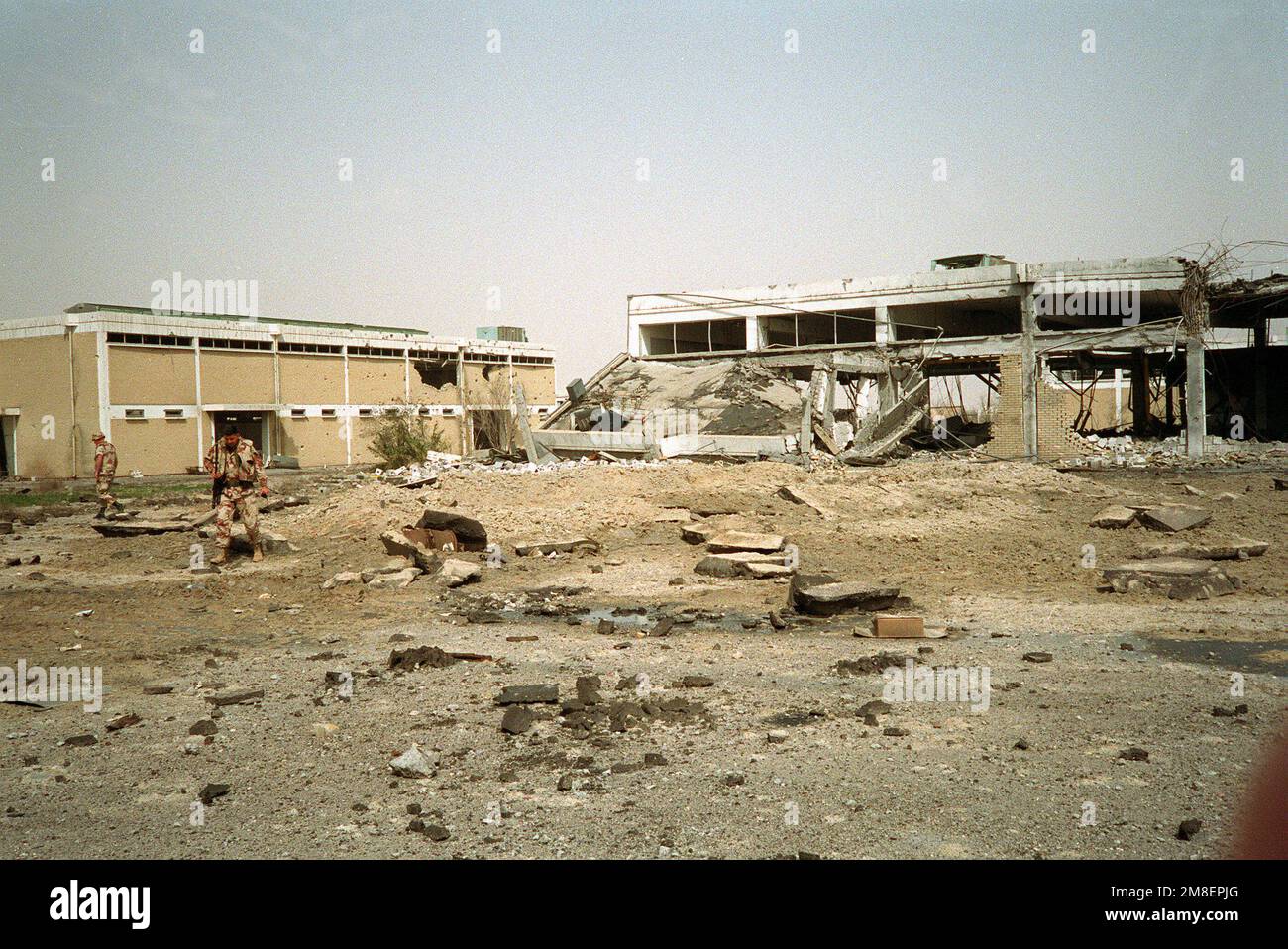 U.S. personnel survey a building at Al Jaber Airfield damaged during ...