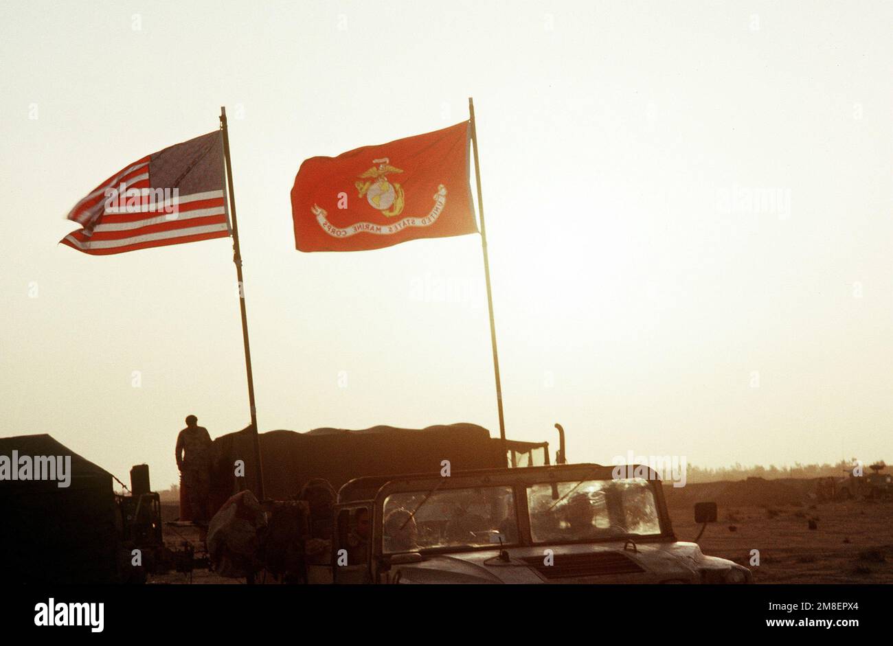The U.S. Marine Corps colors fly from the back of an M998 High-Mobility ...