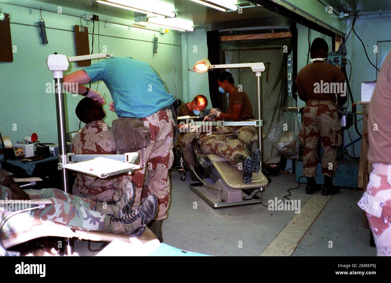 Navy dental technicians work on patients in a field hospital during ...