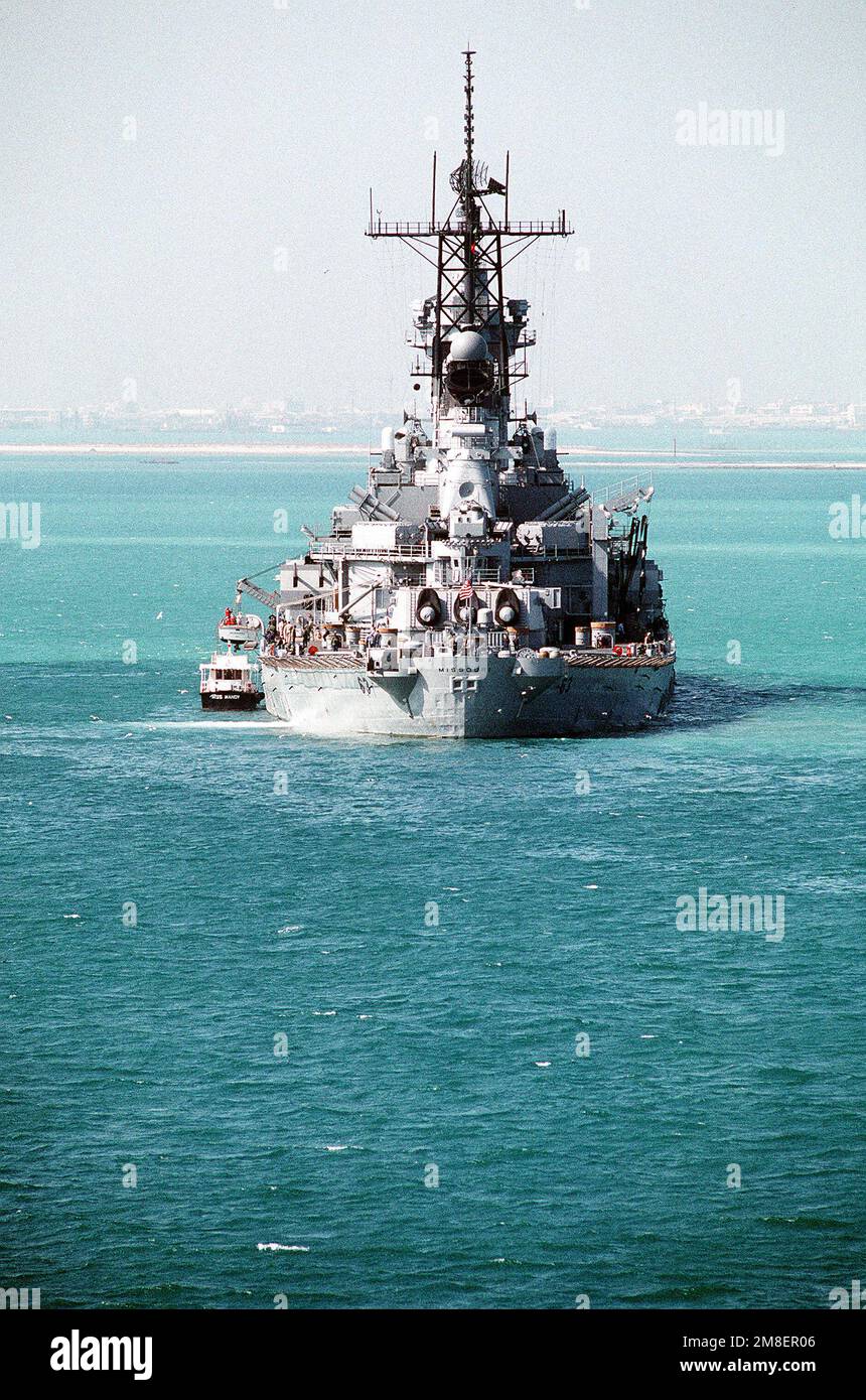 A small boat comes alongside of the battleship USS MISSOURI (BB-63) off ...
