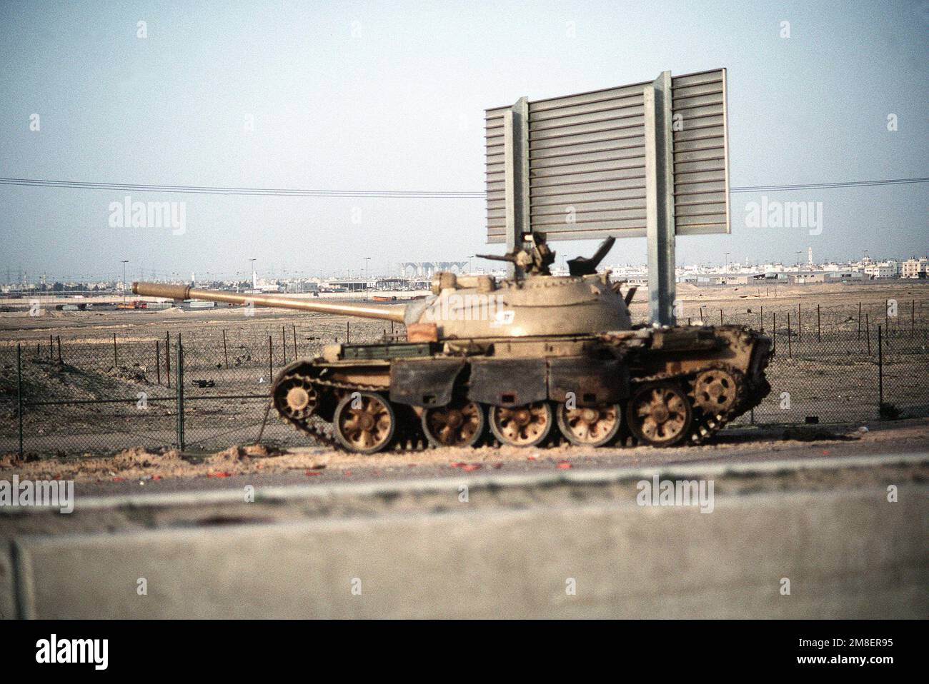 A damaged Iraqi T-55 main battle tank lies abandoned on the side of a ...