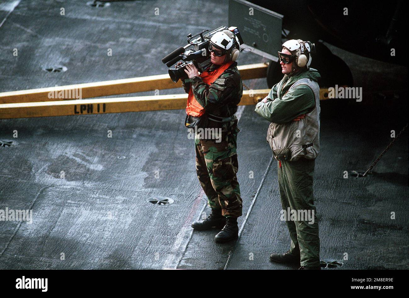 A Navy cameraman videotapes flight operations aboard the amphibious ...