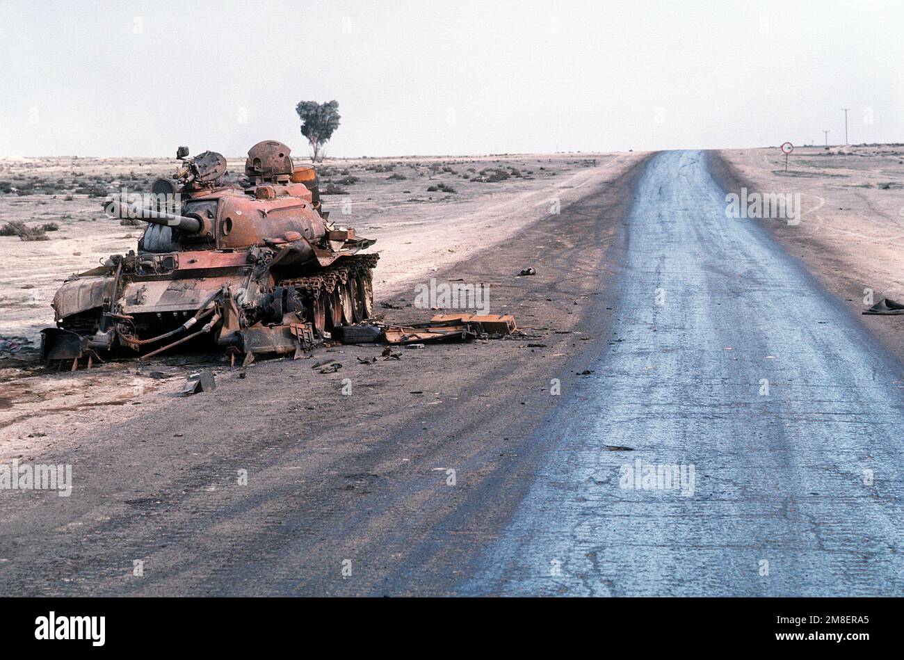 A destroyed Iraqi T-55 main battle tank lies abandoned beside a road at ...