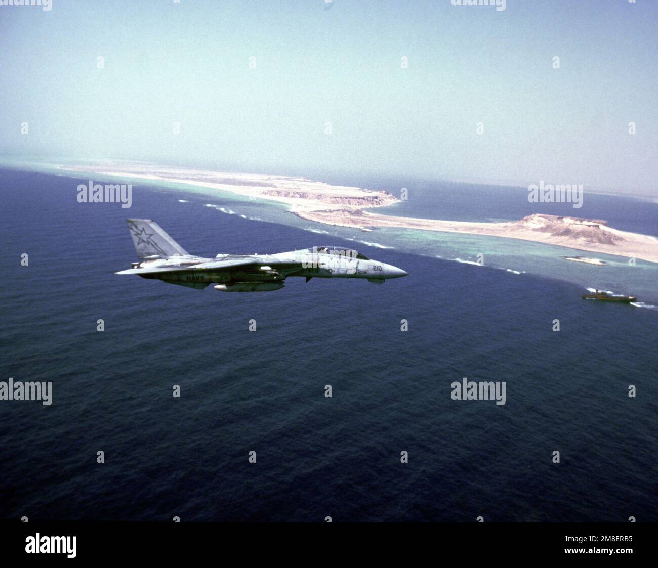 A Fighter Squadron 33 (VF-33) F-14A Tomcat aircraft heads inland during ...