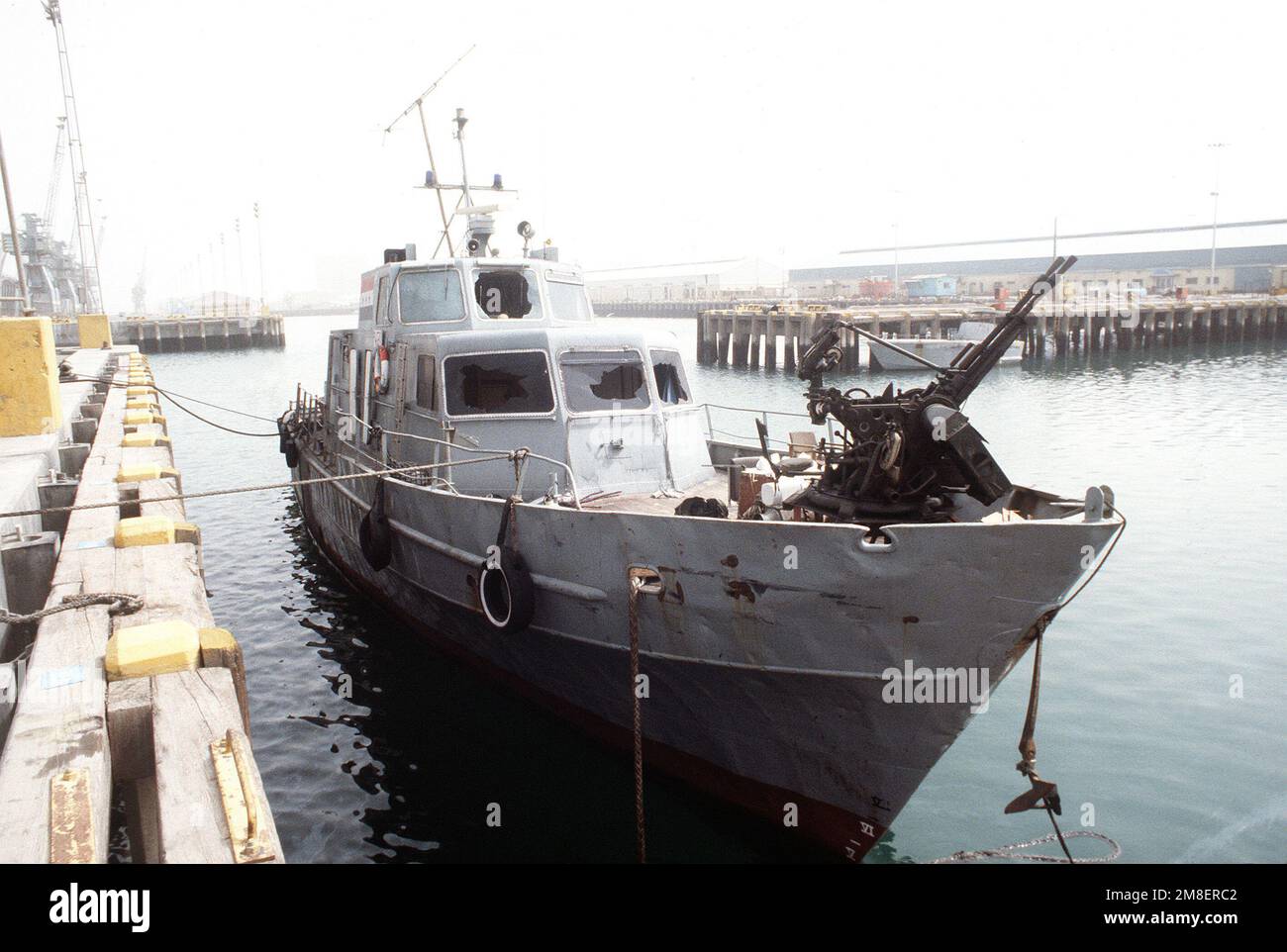 A damaged Kuwaiti navy coastal patrol craft lies tied up at the pier ...