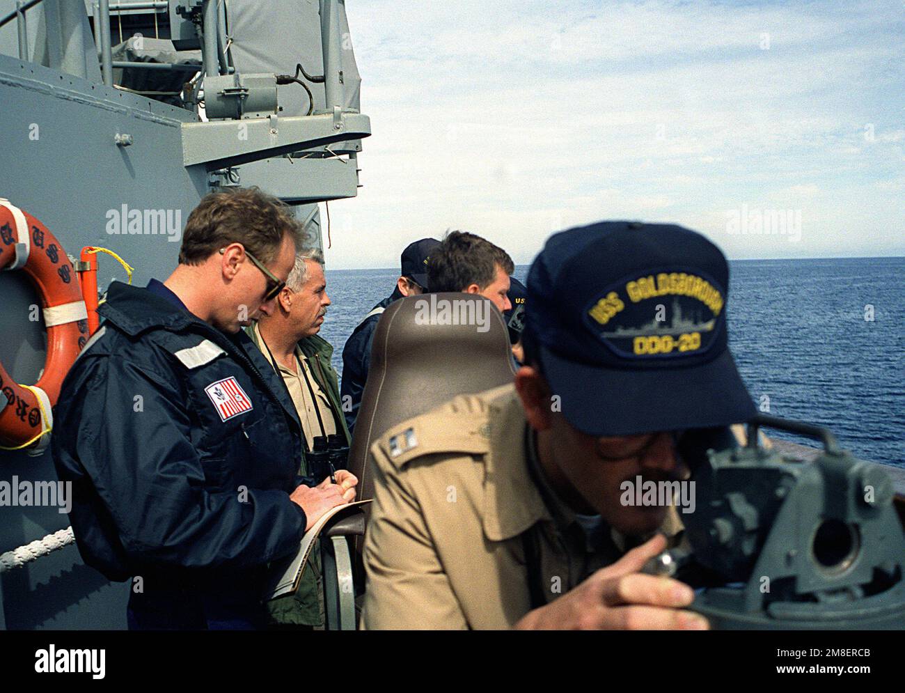 Navy and Coast Guard personnel work on the navigation bridge aboard the ...