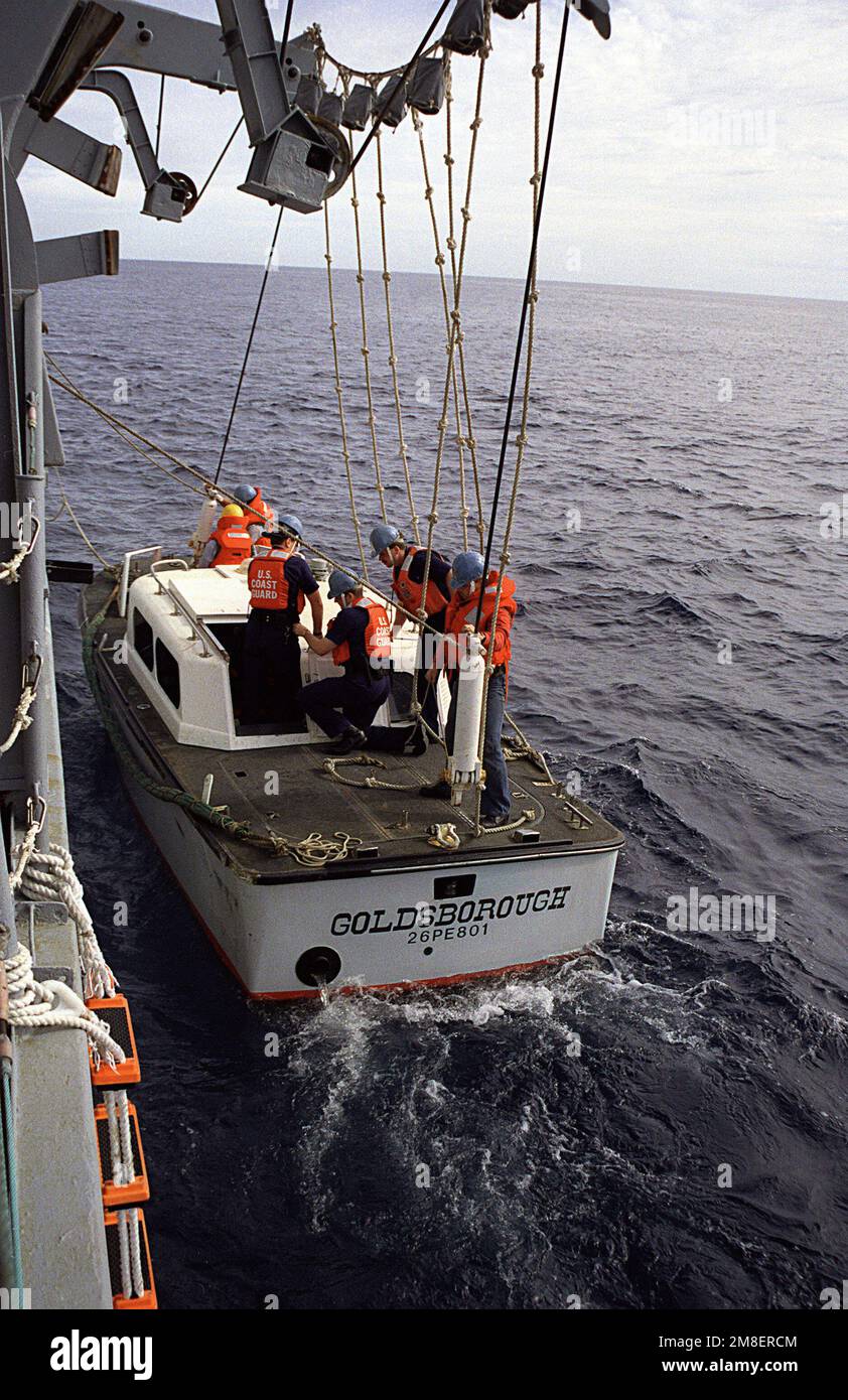 Sailors hold a 26-foot personnel boat from the guided missile destroyer ...