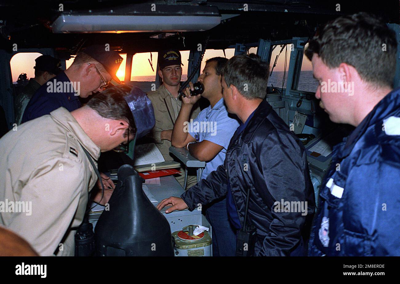 Navy and Coast Guard personnel work on the bridge of the guided missile ...