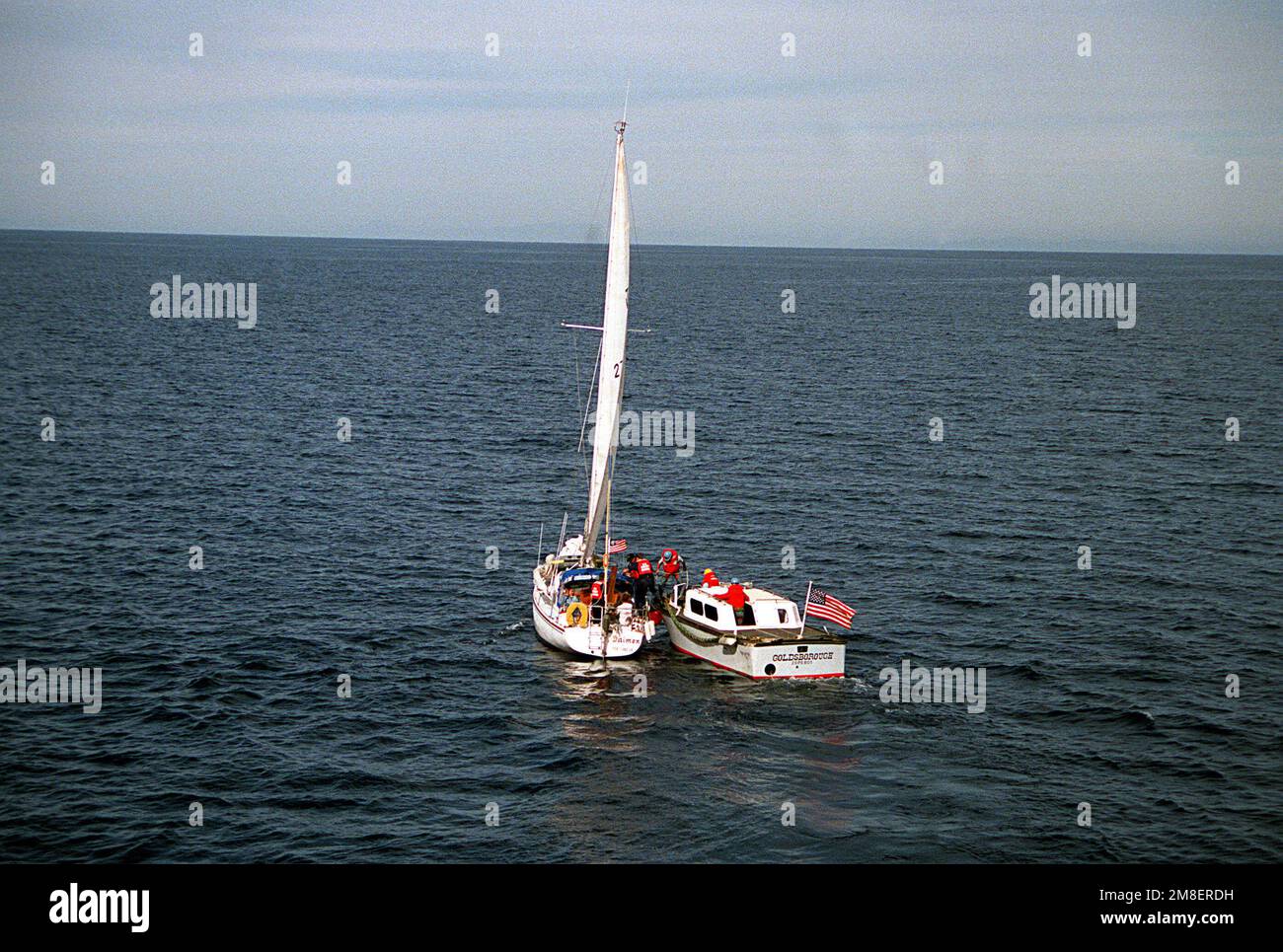 A sailor holds a bumper in place at the bow of a 26-foot personnel boat ...