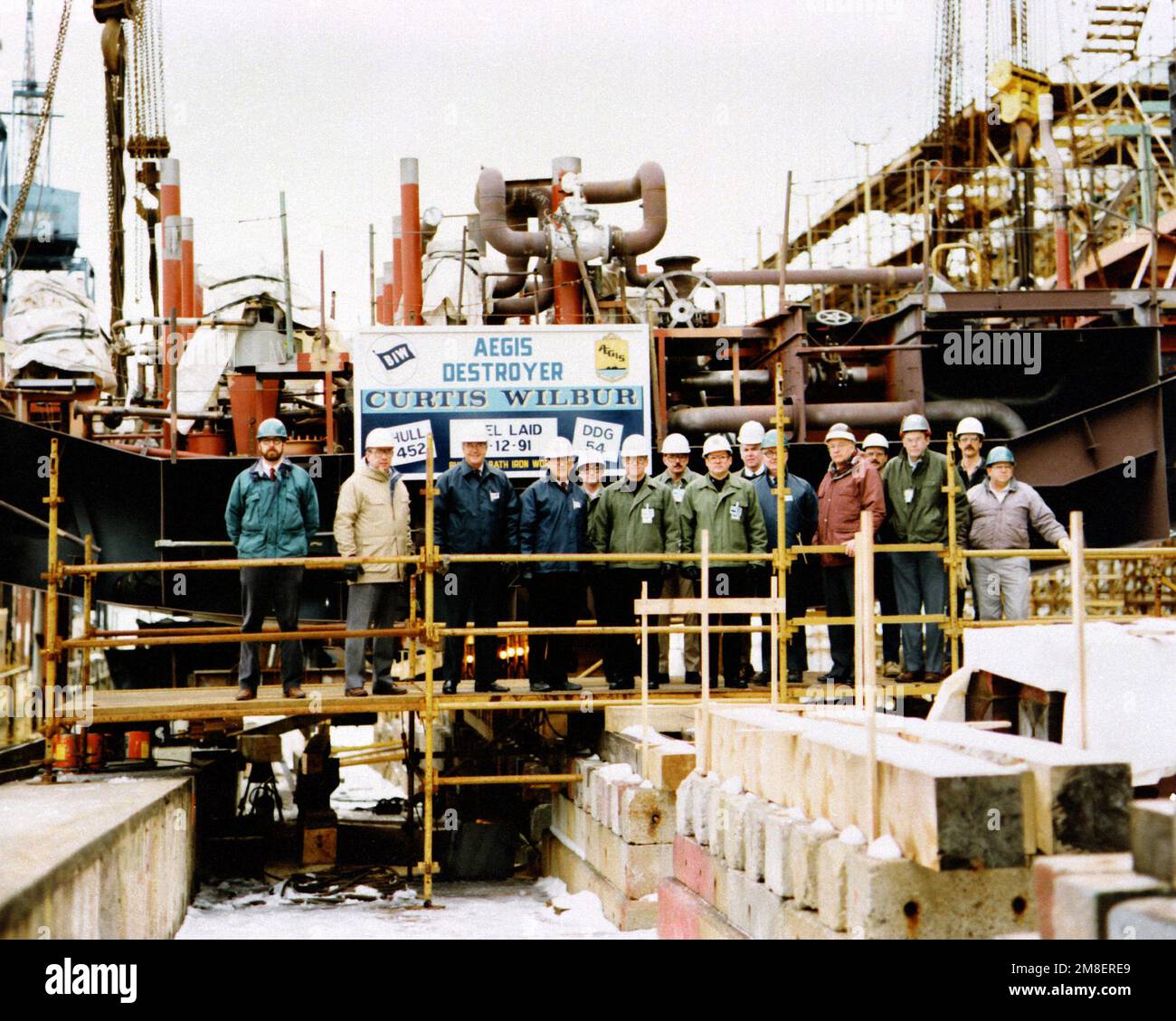 Representatives of Bath Iron Works and U.S. Navy ofHficials pose from a ...