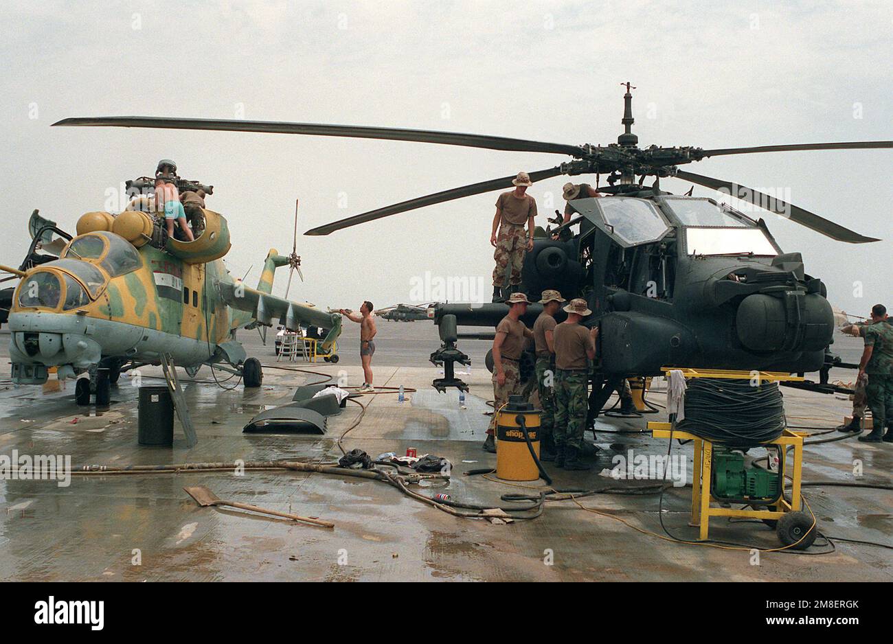 Soldiers of the 1ST Cavalry Division clean an AH-64A Apache helicopter ...
