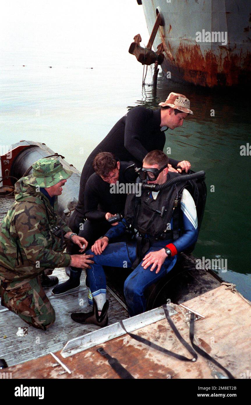 U.S. Navy explosive ordnance disposal (EOD) team members check their ...