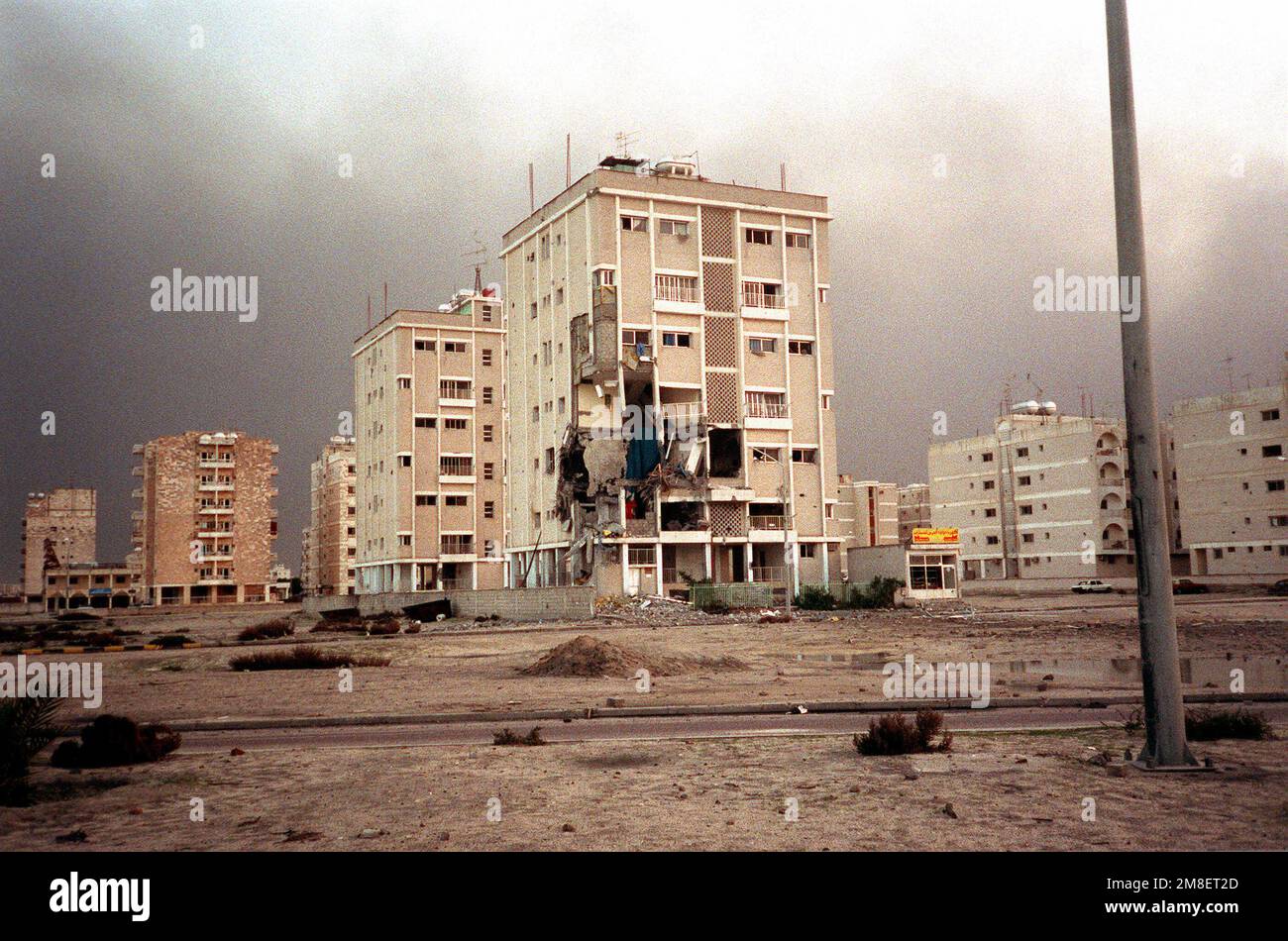 Smoke from oil well fires darkens the sky as buildings display bomb ...