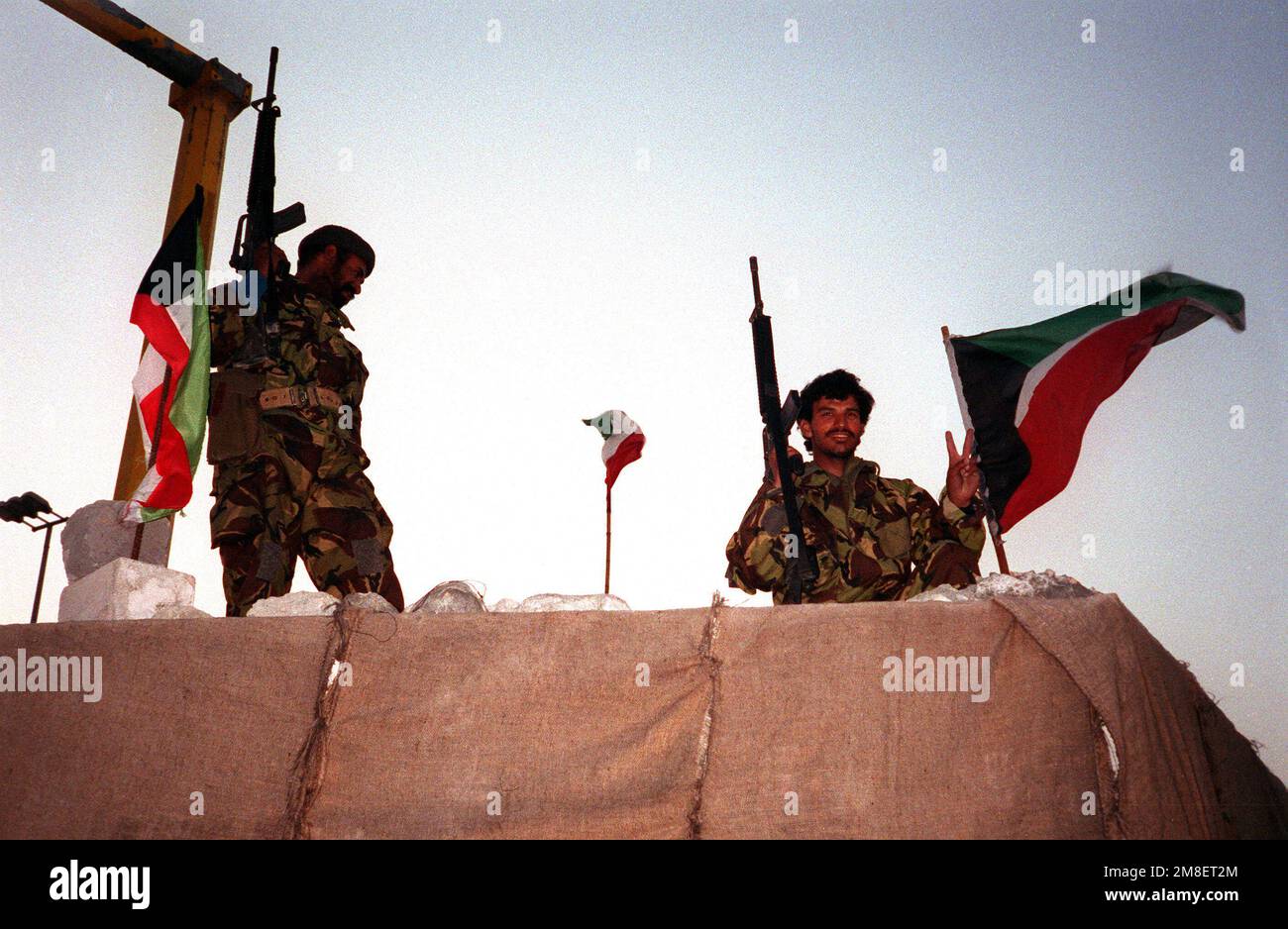 Kuwaiti guards armed with M-16 rifles maintain their post at a roadside ...