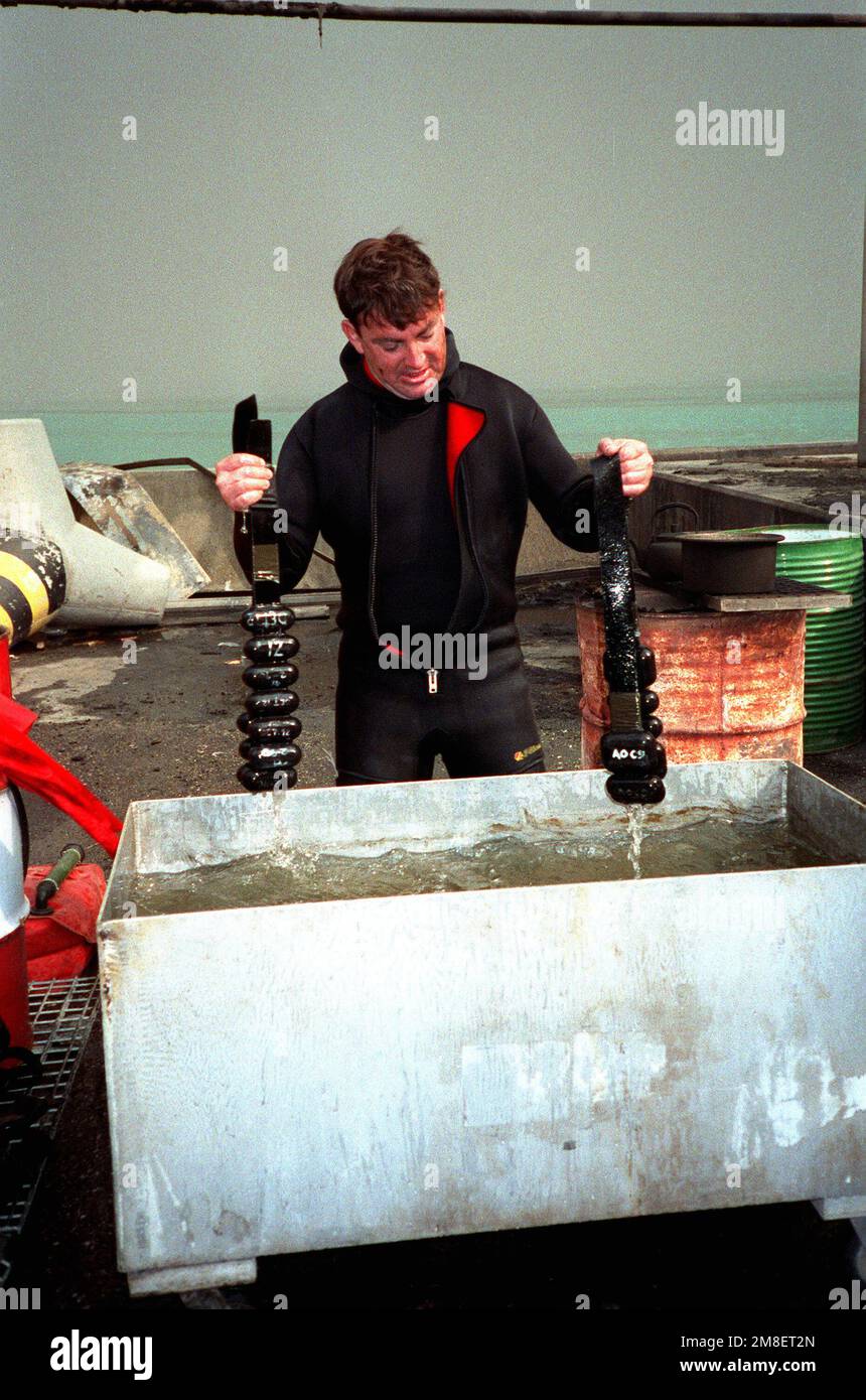 A U.S. Navy explosive ordnance disposal (EOD) team member rinses his ...