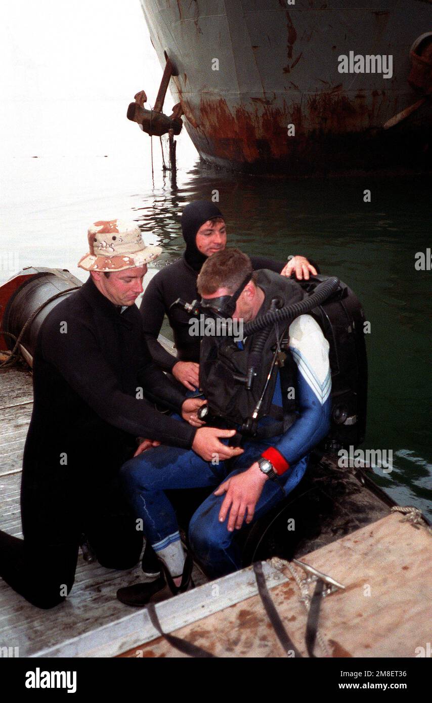 U.S. Navy explosive ordnance disposal (EOD) team members check their ...