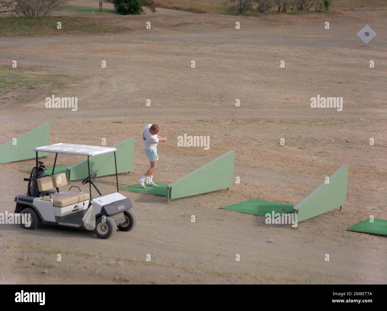 An off-duty sailor practices his swing at the Yatera Secca Golf Course ...