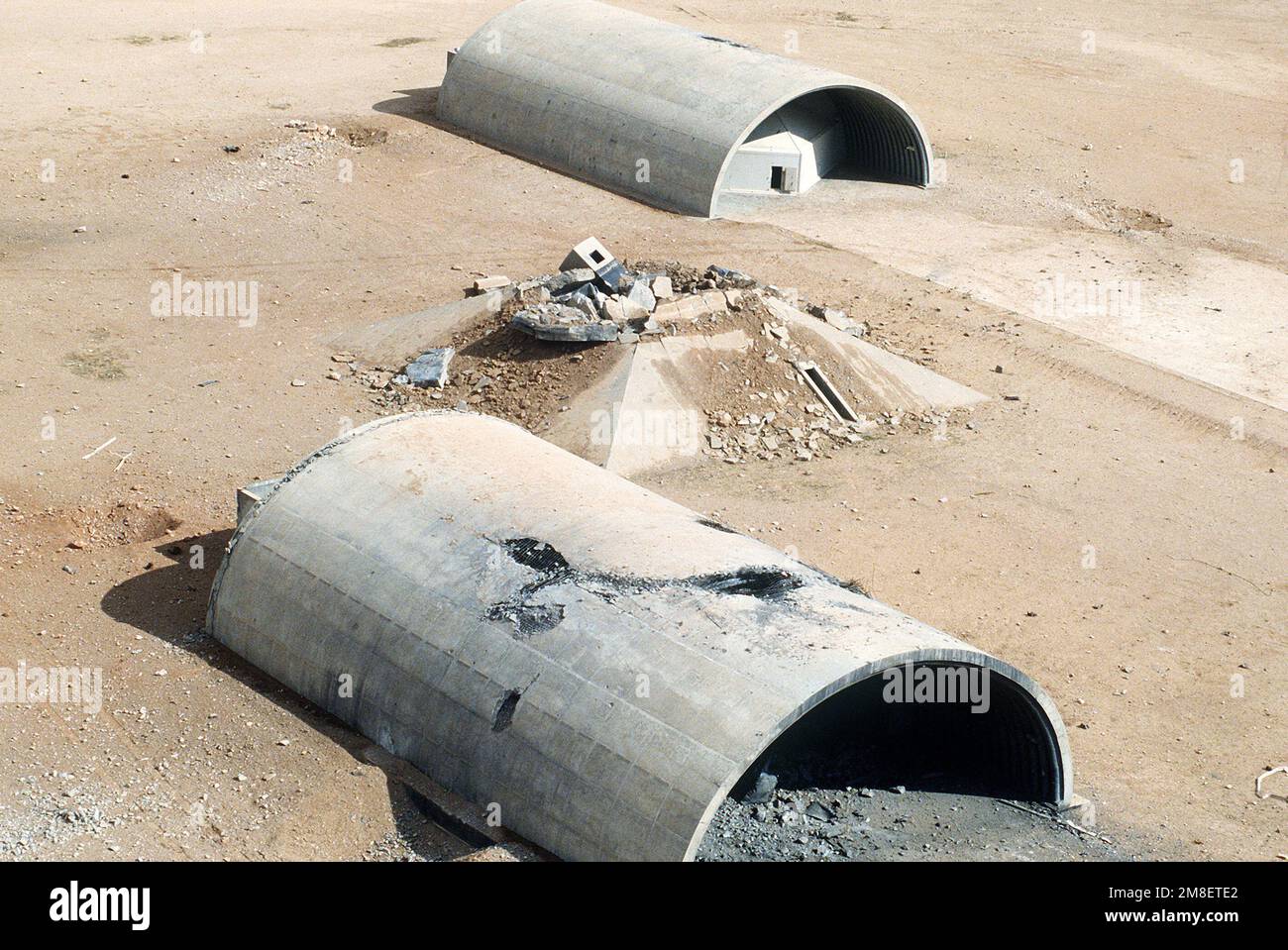 A view of damage to hardened aircraft shelters and concrete munitions ...