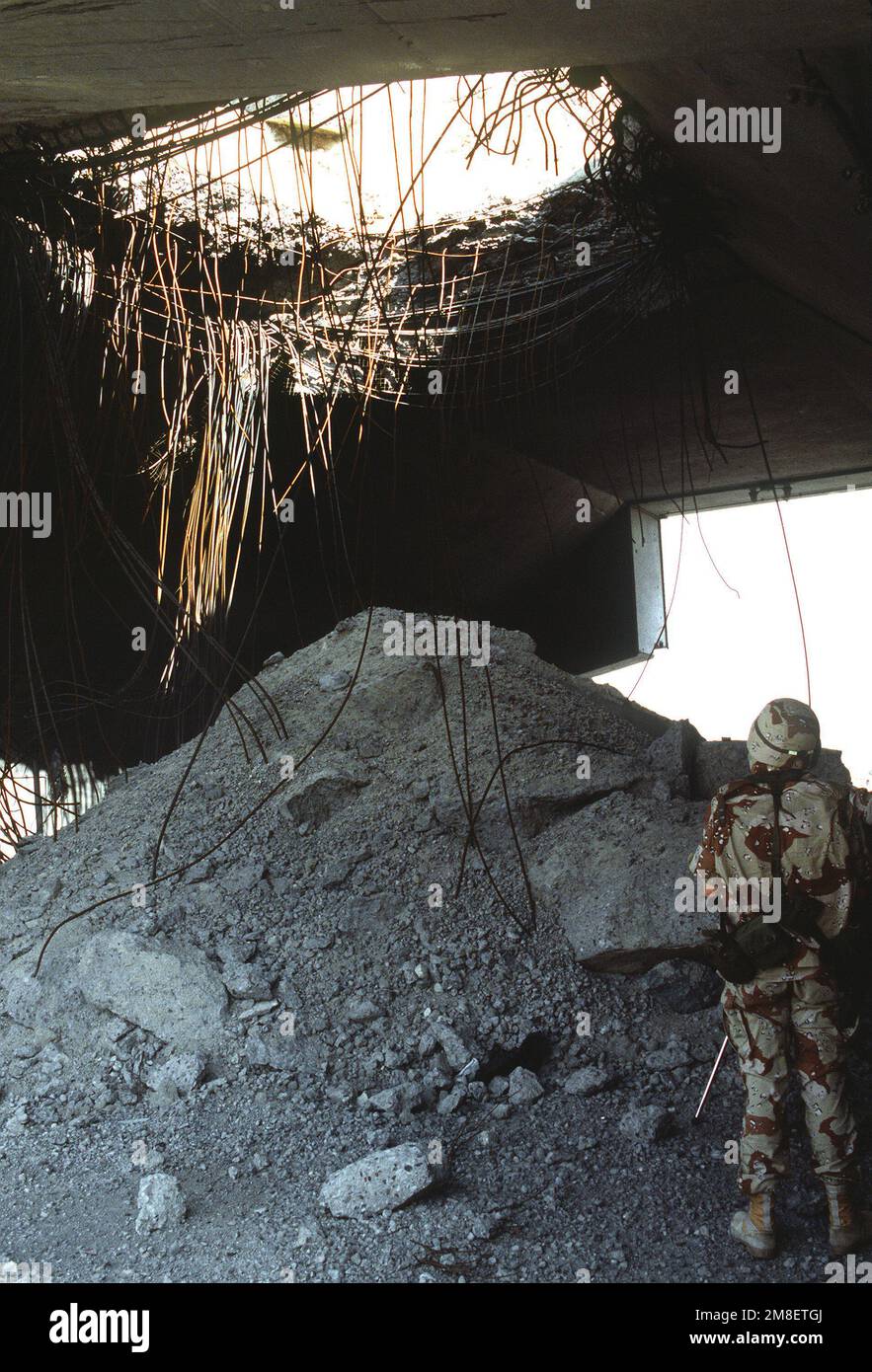 An Allied soldier looka at a large hole in the foof of an Iraqi ...