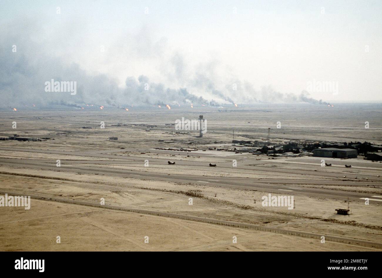 Oil wells burn out of control, darkening the sky with smoke, after ...