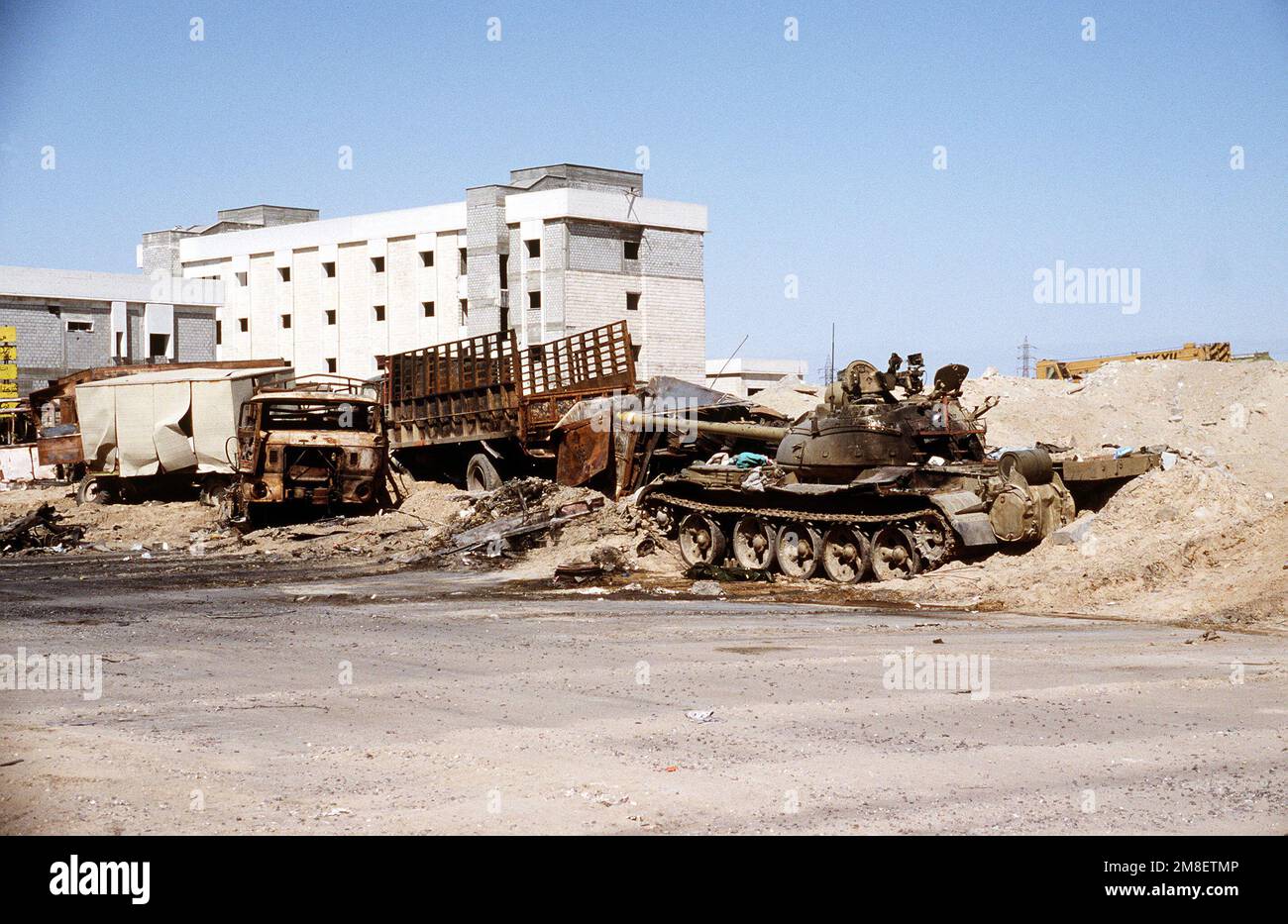 An Iraqi T-55 main battle tank stands on a bank with other demolished ...