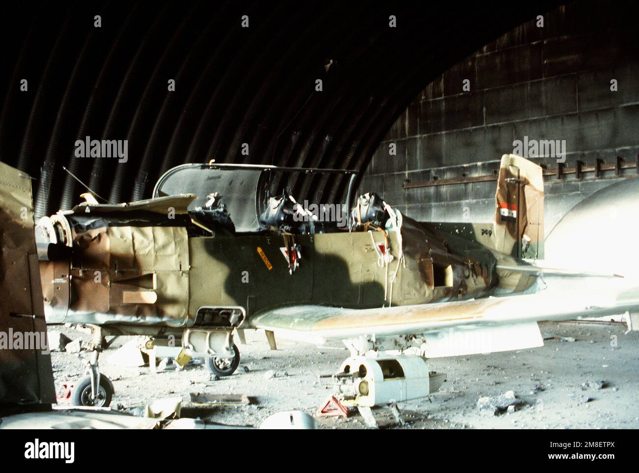 A demolished Iraqi aircraft sits in a bombed out hangar in the ...