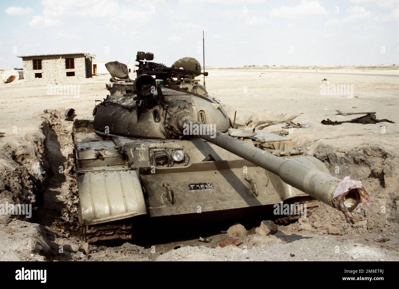 A destroyed Iraqi T-55 main battle tank stands in the sand at Jalibah ...