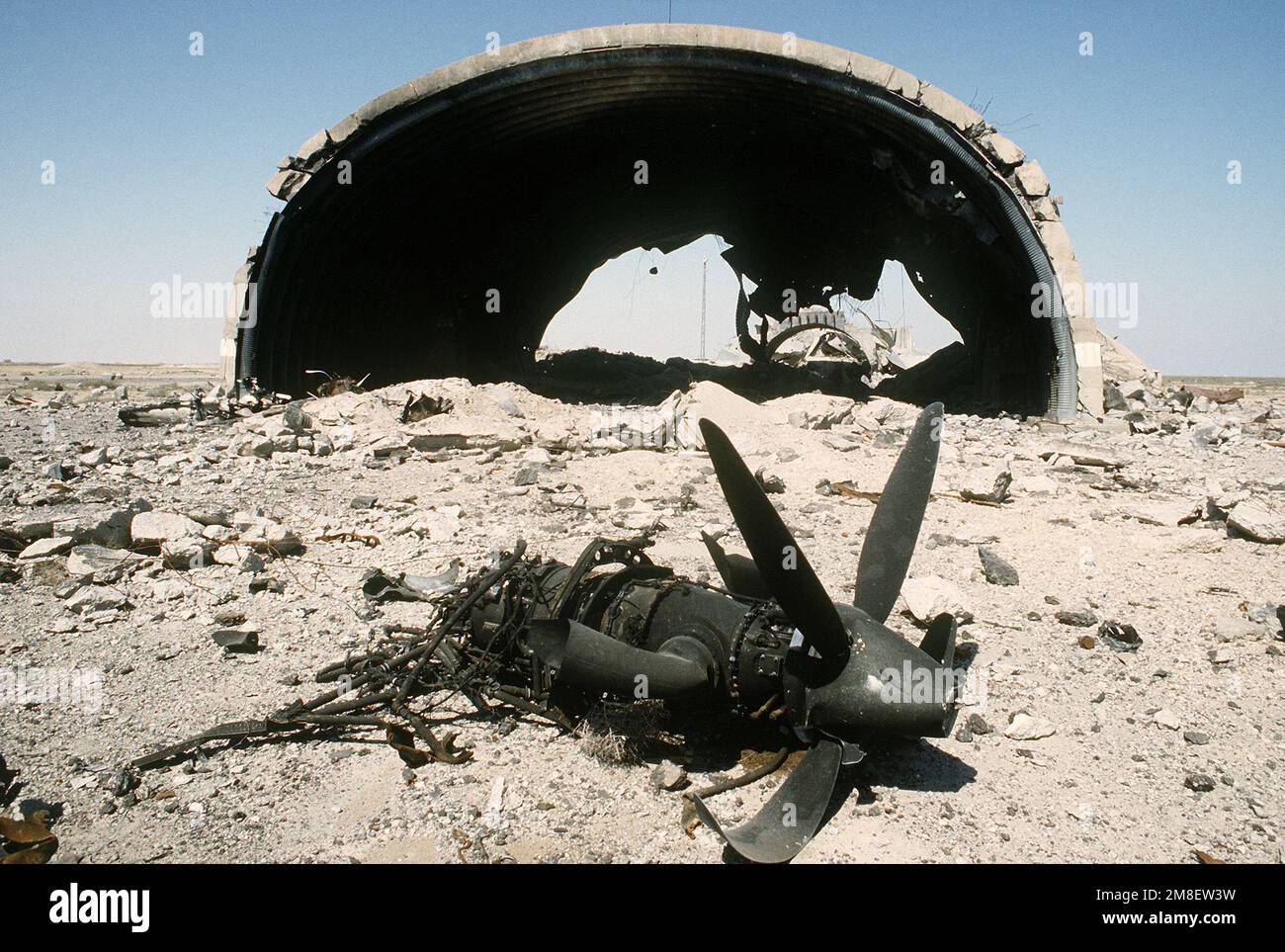 A view of an aircraft engine lying in front of a demolished hardened ...