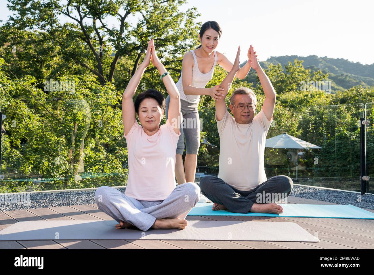 A young woman in guiding a pair of exercise in the elderly Stock Photo ...