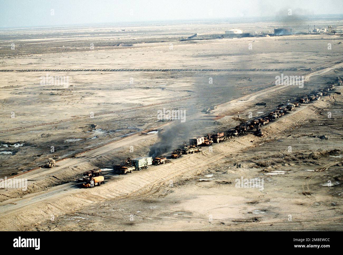 Demolished Iraqi vehicles line a roadway in the Euphrates River Valley ...