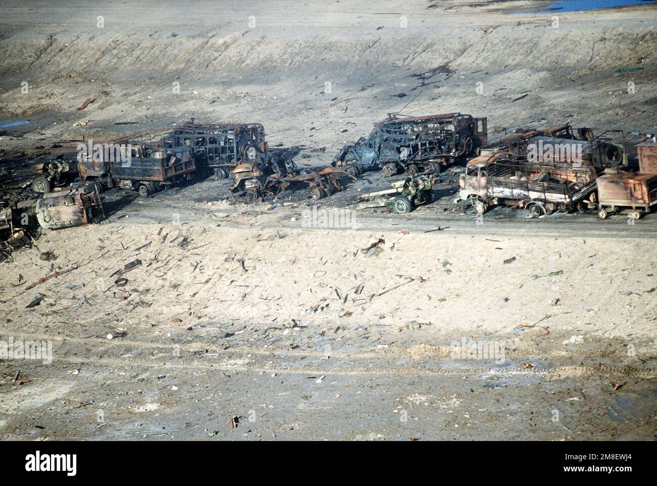 Demolished Iraqi vehicles line a roadway in the Euphrates River Valley ...