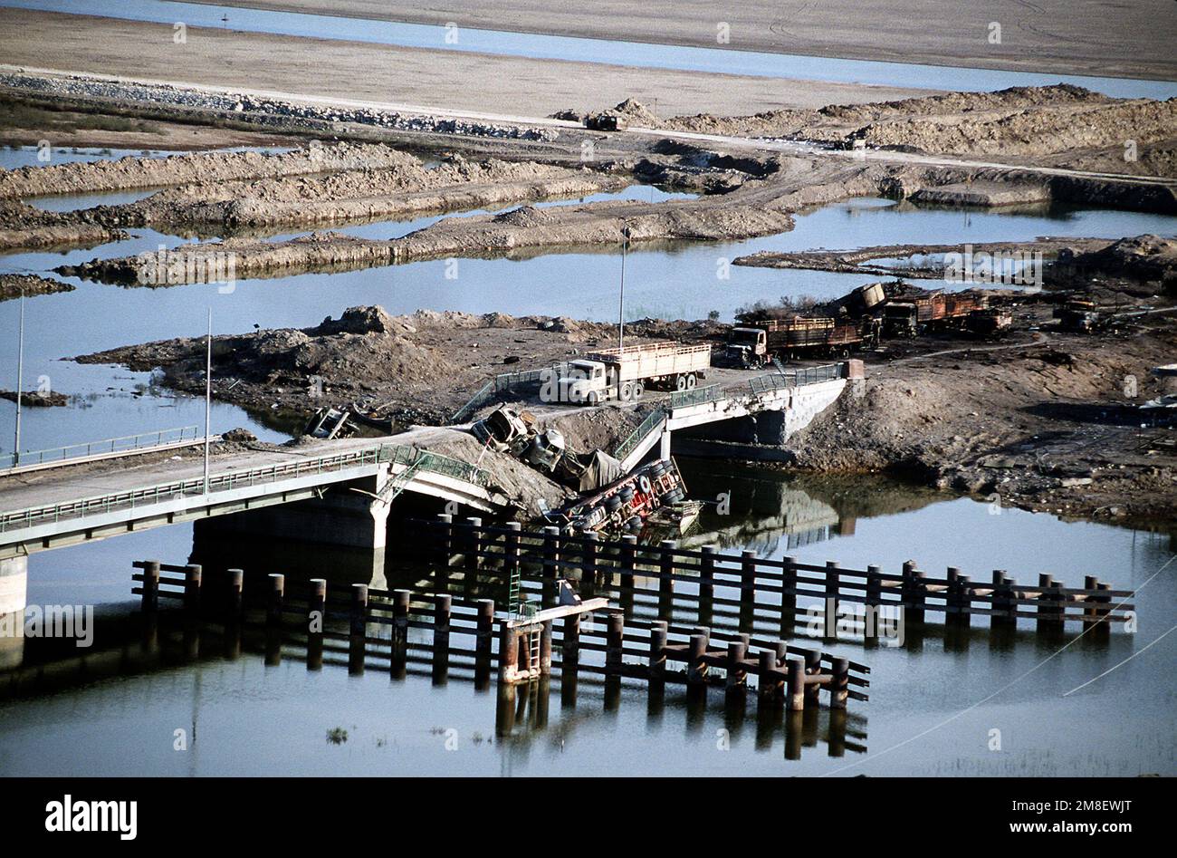 A section of collapsed bridge and demolished Iraqi vehicles in the ...
