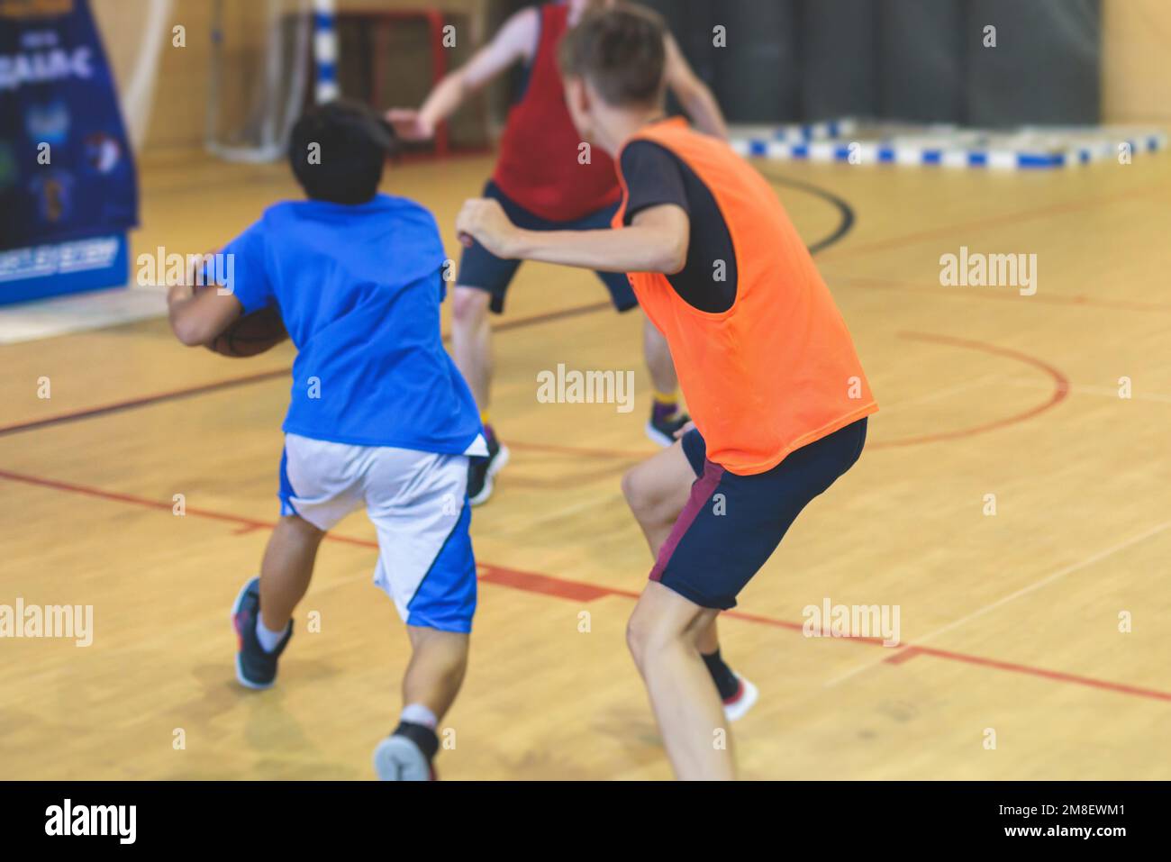 School children playing basketball in sports hall hi-res stock ...