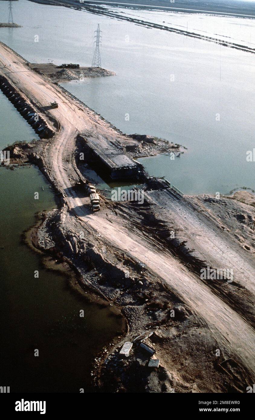 Abandoned and damaged Iraqi vehicles stand on the earthen bypass for a ...