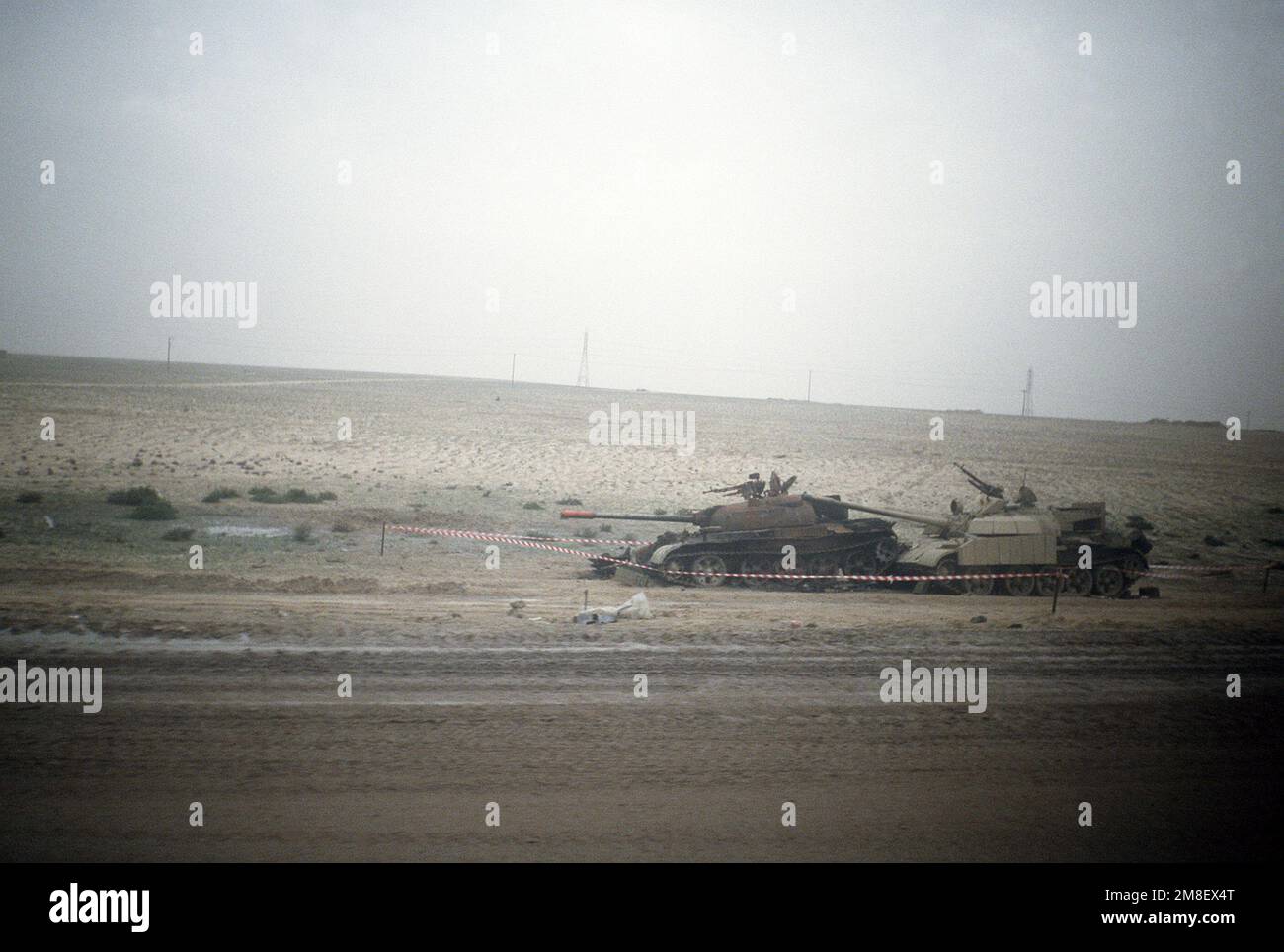 Demolished Iraqi T-55 main battle tanks lie stranded on the side of the ...