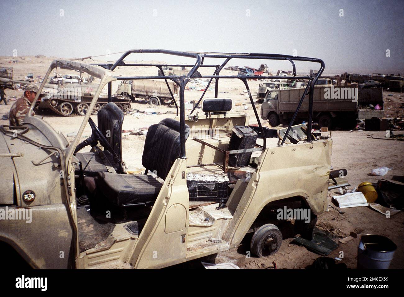 A demolished Iraqi UAZ-469B light vehicle is abandoned on a roadway ...