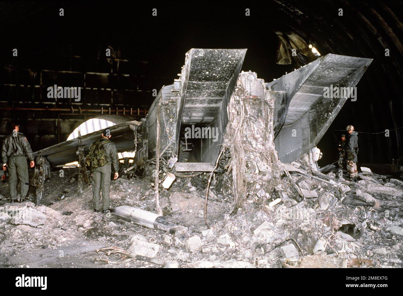 Coalition military personnel inspect the remains of an Iraqi aircraft ...