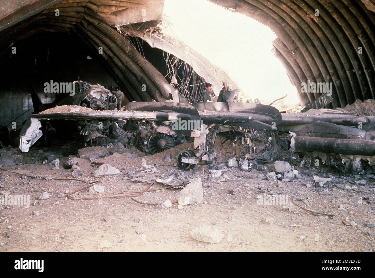 Coalition military personnel inspect the remains of an Iraqi SU-22 ...