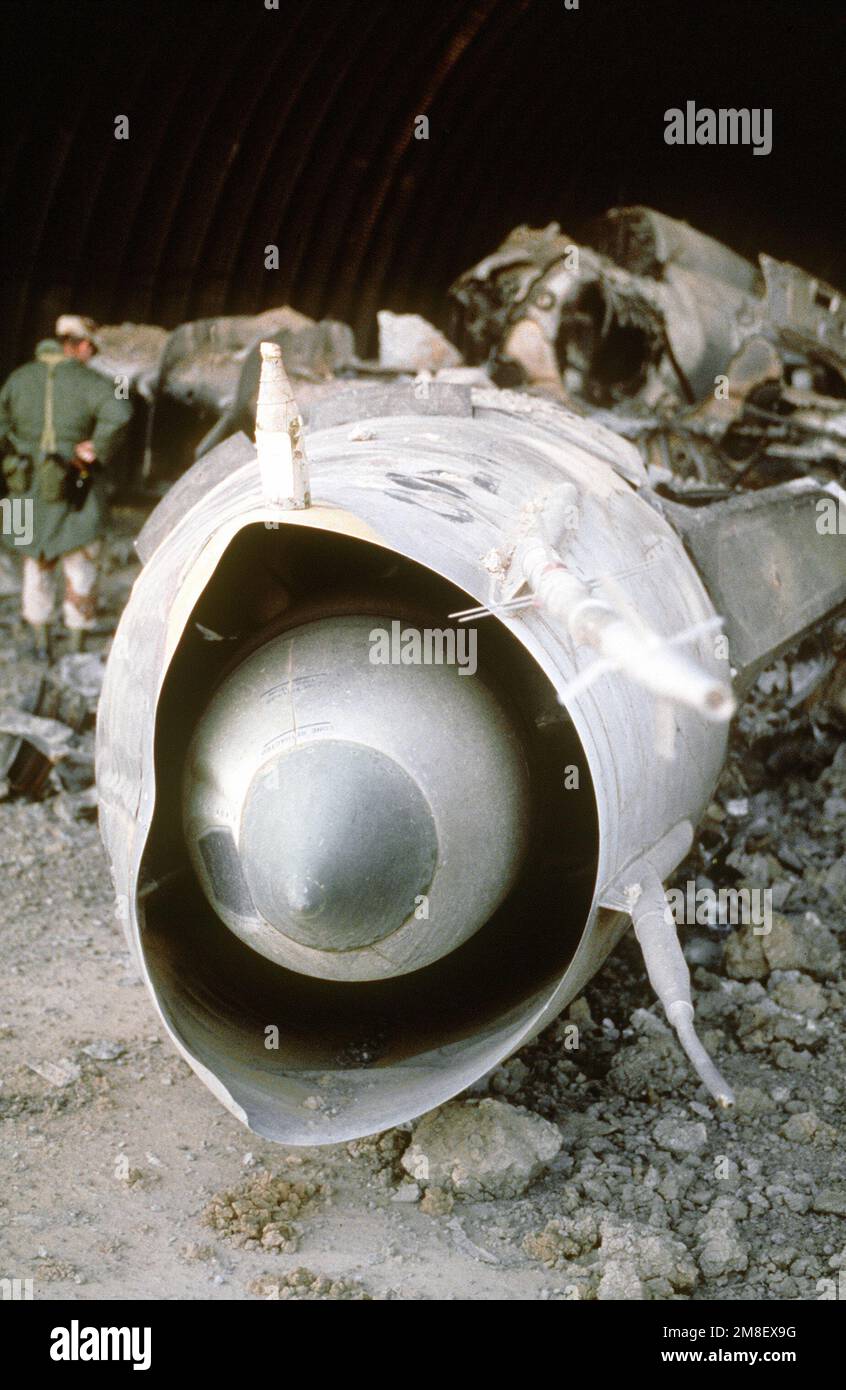 An unbroken bottle sits atop the nose of a demolished Iraqi Su-22 ...