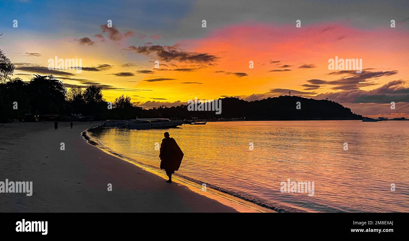Monk walking at sunrise on Pattaya Beach in Koh Lipe, Satun, Thailand ...