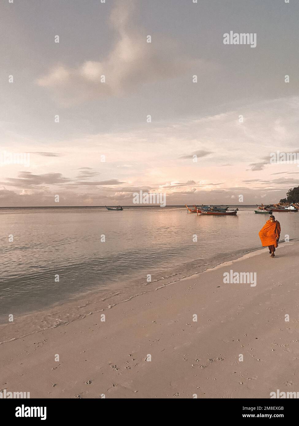Monk walking at sunrise on Pattaya Beach in Koh Lipe, Satun, Thailand ...