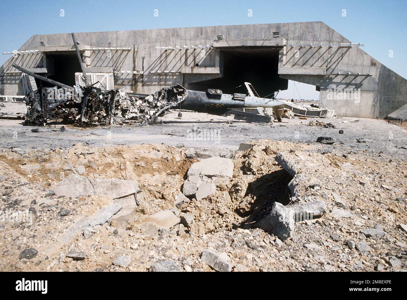 A demolished hangar and helicopter exemplify the devastation resulting ...