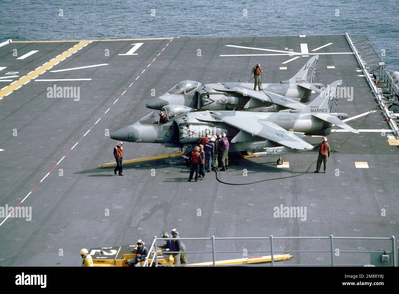 Maintenance and refueling personnel gather around two Marine Attack ...